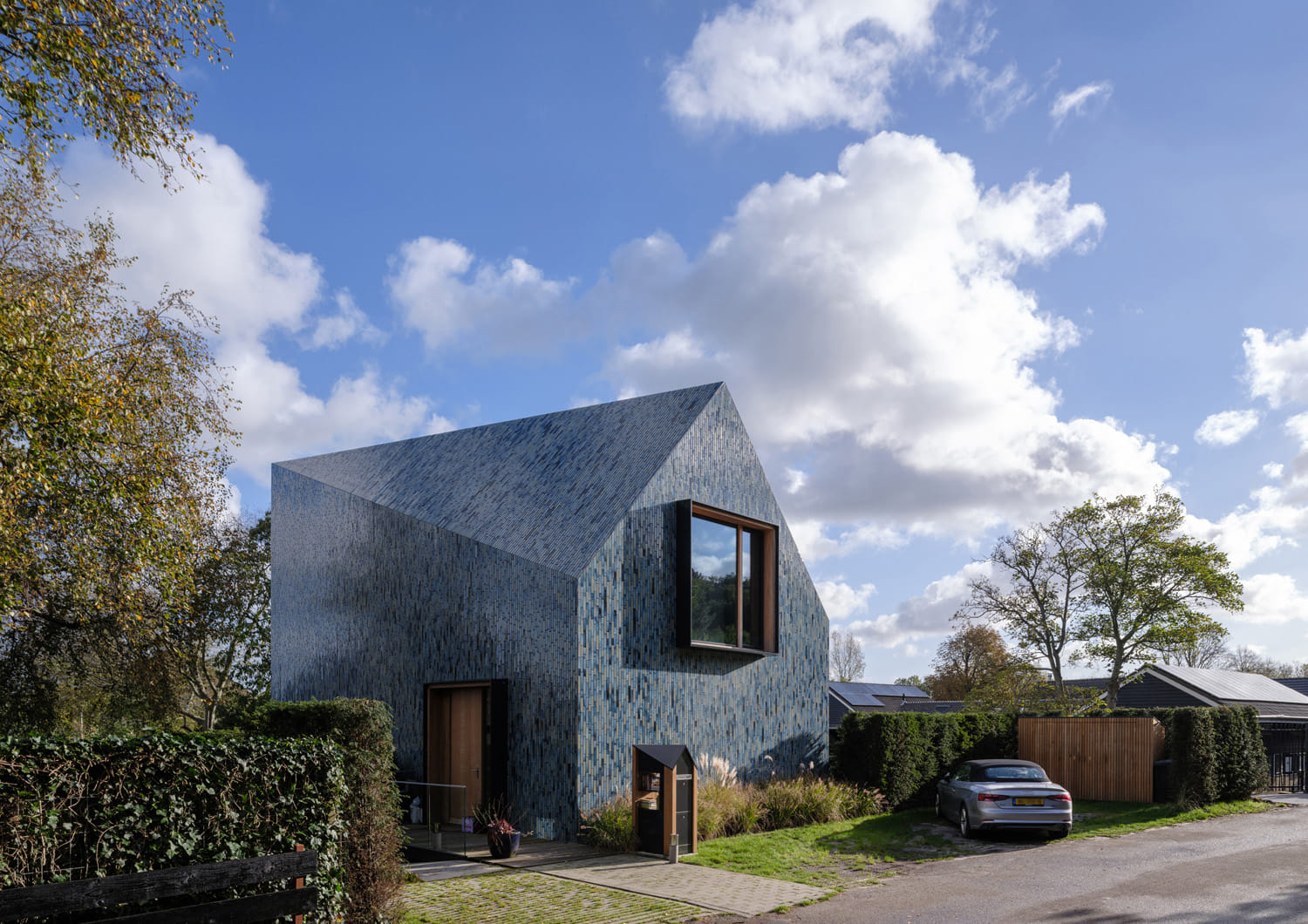 This double-curved roof house by Mecanoo is covered in slick ...